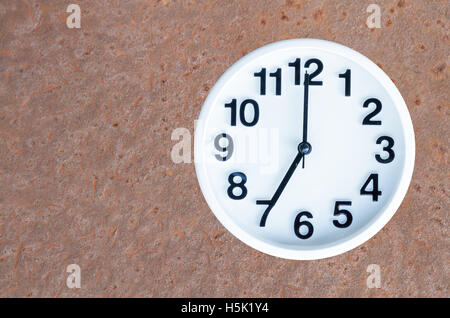 Wall clock show seven o'clock on white marble texture. Office clock ...