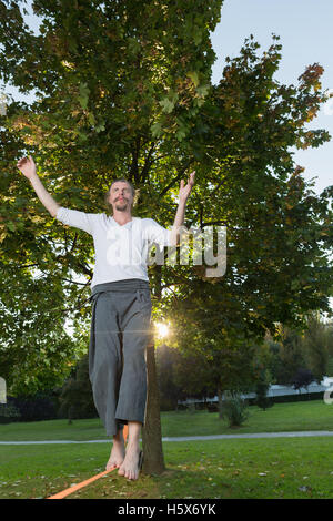 Portrait of man on slackline. Slacklining is a practice in balance ...