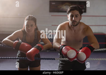 Young female boxer leaning on boxing ring ropes chatting Stock Photo ...
