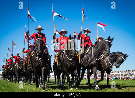 Mountie in red ceremonial uniform on black RCMP horse on the lawn in ...