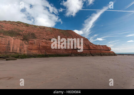 Red rocky cliffs on Exmouth beach at low tide. Jurassic heritage coast ...