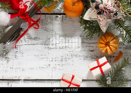 Christmas fir tree with cones, tangerines and a gift on a wooden ...