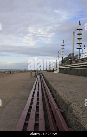 Benches on a promenade by the sea on a cloudy day at dusk Stock Photo ...