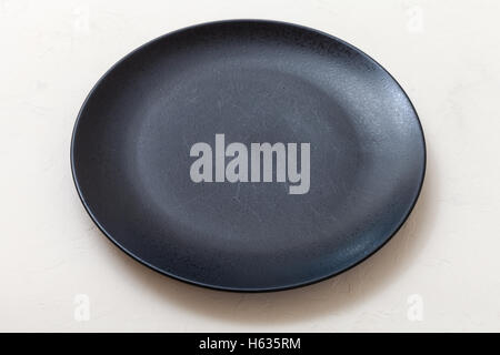 black plate on white plastering board Stock Photo - Alamy