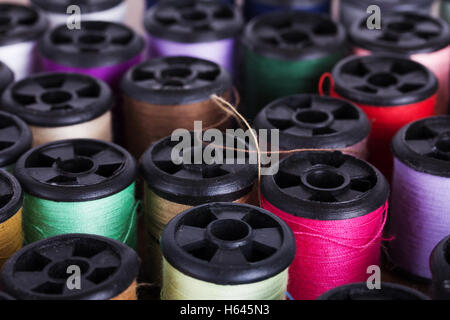 Scattered coloured cotton reels on a wooden surface Stock Photo - Alamy
