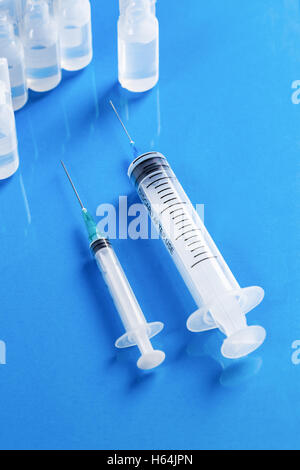 medical syringes on blue background Stock Photo - Alamy