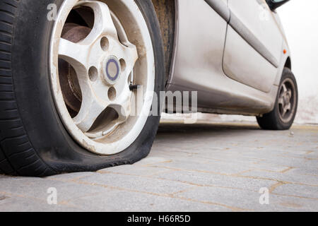 Parked car with a deflated tyre Stock Photo - Alamy