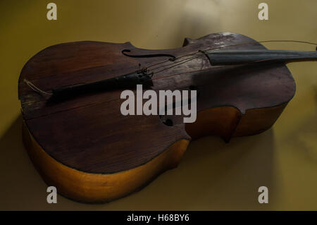 Old worn vintage cello hanging on yellow wall Stock Photo - Alamy
