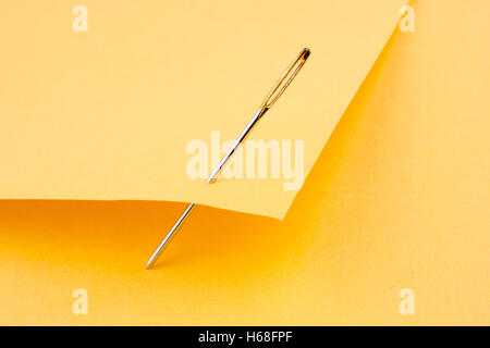 Needle pierced yellow color note paper Stock Photo - Alamy