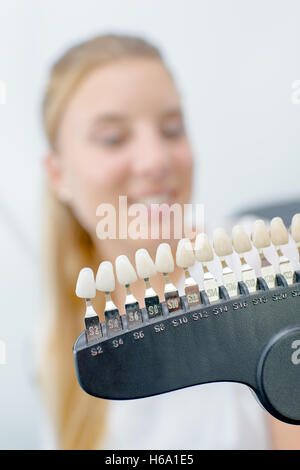 Dentist showing teeth color shades guide for tooth whitening for ...