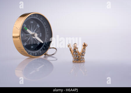 Compass and Golden color crown model with pearls on white background ...