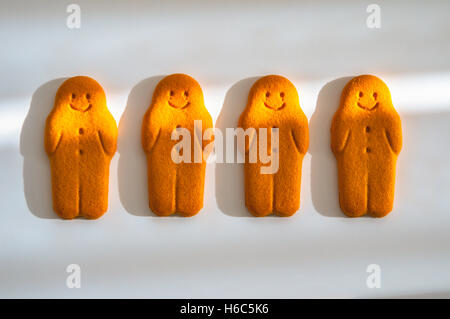 Gingerbread men in a line, red ribbon Stock Photo - Alamy