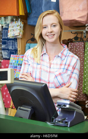 Happy female customer at cashier desk preparing to pay for her picking ...
