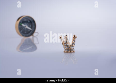 Compass and Golden color crown model with pearls on white background ...