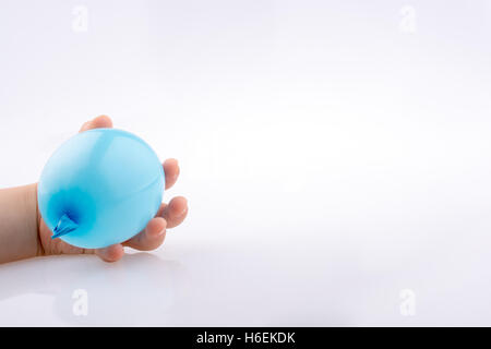 Hand holding a Colorful small balloon with colorful balloons on the ...