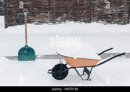 Snow shovel and wheelbarrow Stock Photo - Alamy