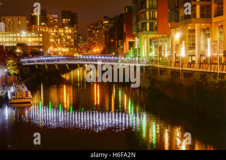 Illuminated footbridge crossing the River Irwell joining Spinningfields ...