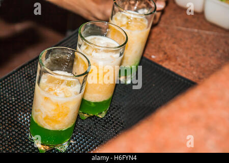 the bartender at the bar makes the three-layered cocktail Stock Photo ...