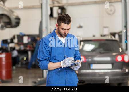 auto mechanic with clipboard and man at car shop Stock Photo - Alamy