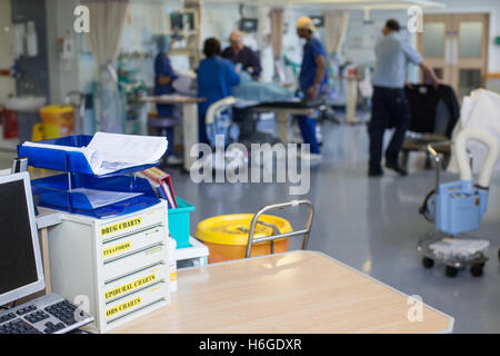 Hospital workstation in a ward with nurses attending to patients' needs ...