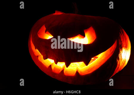 Evil smiling glowing halloween pumpkin on dark background Stock Photo ...