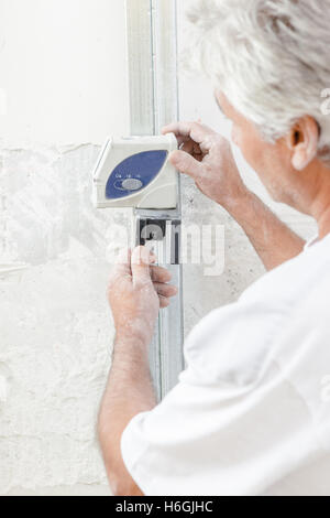 professional worker using laser level in a building under construction ...