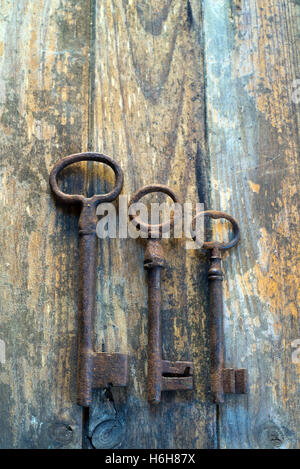 Three old keys on wooden table Stock Photo - Alamy