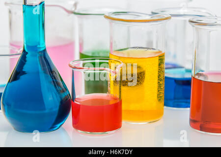 various beakers with different types of indicators in acids and basis ...