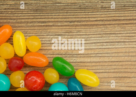 Colorful jelly beans shaped a frame to write your text on a wooden ...
