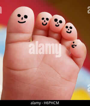 little newborn baby feet with smiley emoticons drawn on them Stock ...