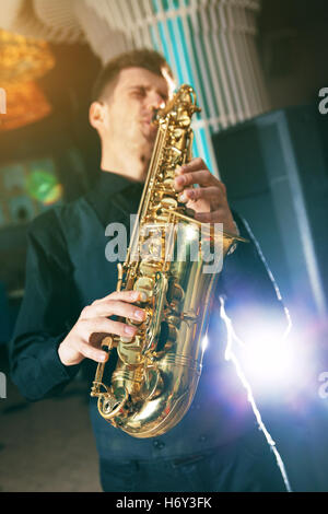 A man playing on saxophone and notes coming out isolated against ...
