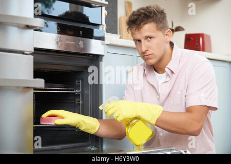 Man cleaning oven at home Stock Photo - Alamy