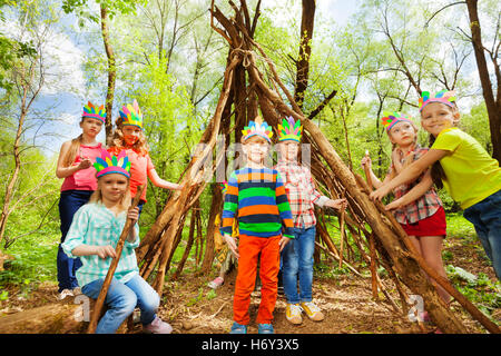 Happy kids building wigwam in the forest Stock Photo - Alamy