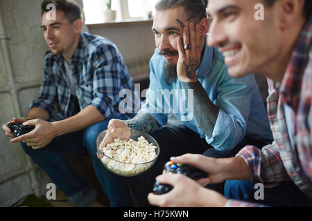 Young gamer man with tattoo playing video game standing over isolated ...