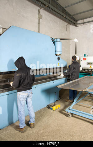 metalworker cutting iron sheets with a machine Stock Photo - Alamy