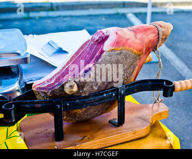 Whole bone-in leg of Spanish serrano iberico ham being carved at a ...