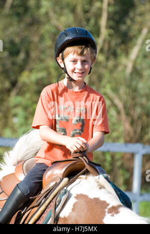 Eight-year-old boy looks in mirror while brushing hair at home in ...
