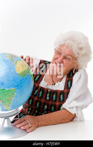 an elderly woman smiles and shows with her hand to the side on a light ...