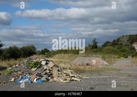 Rubbish dumped on waste ground with cooling towers of a power station ...