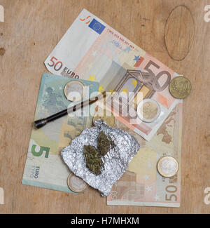 Marijuana in tin foil with pipe on wooden table Stock Photo - Alamy
