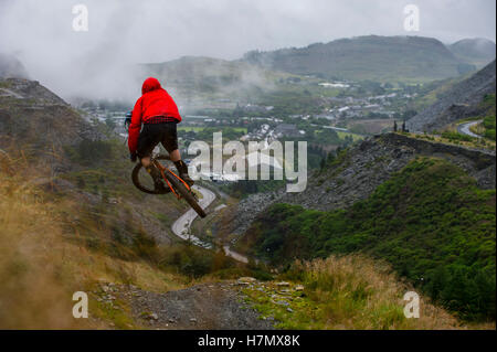 A mountain biker jumps a rock drop at Antur Stiniog mountain bike ...