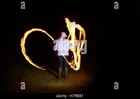 A woman performing with fire poi Stock Photo - Alamy