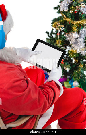 Tablet on Christmas background with santa hat and gift box. New Year ...