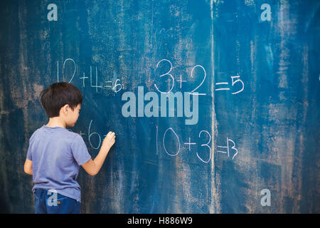 Rear view of boy at chalkboard doing math formulas Stock Photo - Alamy