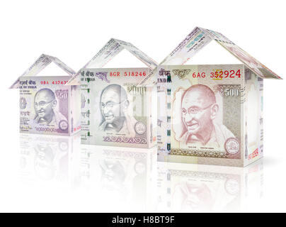 Money bills folded like houses standing next to a credit card ...