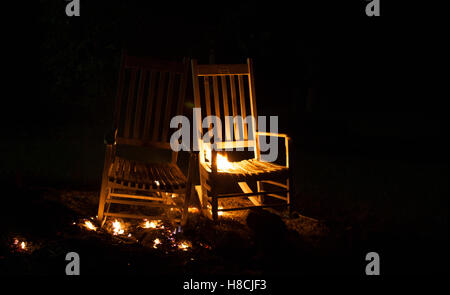 Two rocking chairs that are just beginning to burn Stock Photo - Alamy
