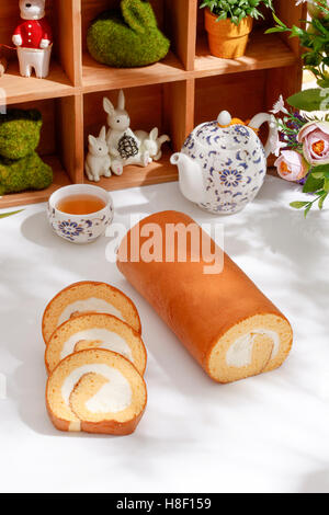 Plate with delicious sponge cake roll, fresh strawberries, floral decor ...