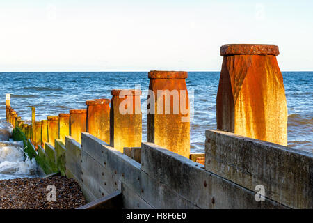 Sea wall and wooden groynes coastal defences on the beach at Walton on ...