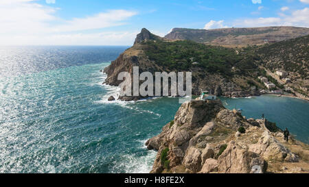 Promenade on a cliff by the sea on a sunny day seen from a covered ...