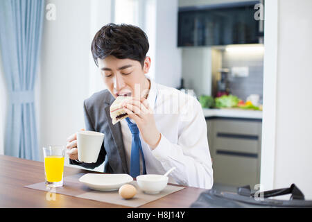 Young Chinese businessman having breakfast in a hurry Stock Photo - Alamy